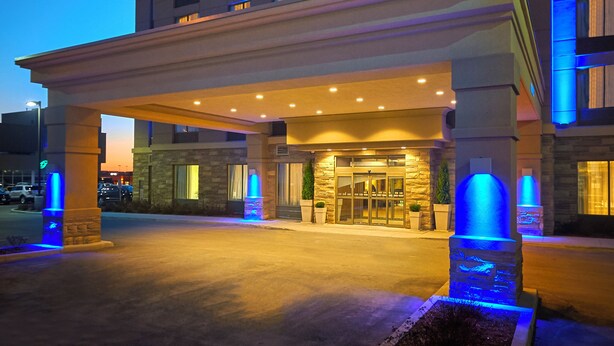 Edifício Holiday Inn Express & Suites com fachada moderna, janelas amplas e entrada bem iluminada.