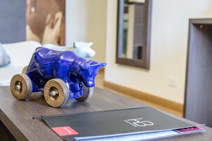 Uma estatueta de touro azul de cerâmica sobre uma mesa de madeira com uma pasta preta com um logotipo branco.