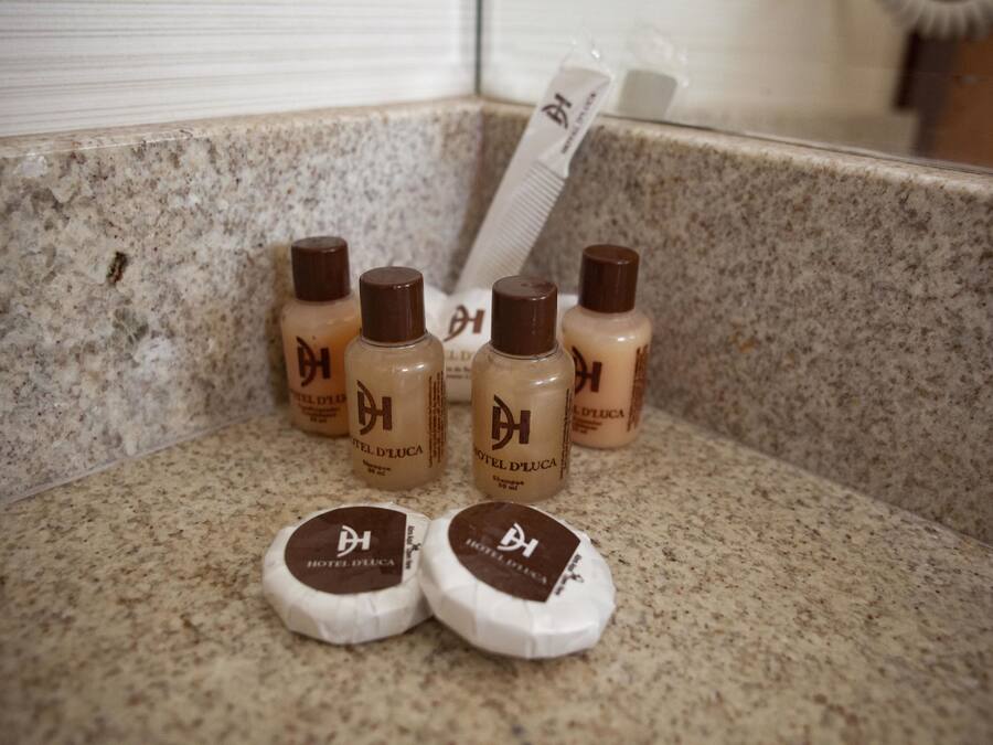 Uma bancada de banheiro com produtos de higiene pessoal, incluindo frascos e um pente.