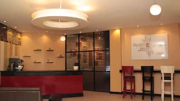Interior moderno de café com balcão vermelho, cadeiras pretas e brancas e um cartaz com nuvem de palavras na parede.