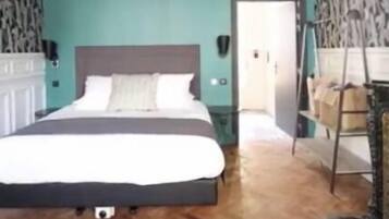 Quarto com uma cama grande, um guarda-roupa e um espelho.