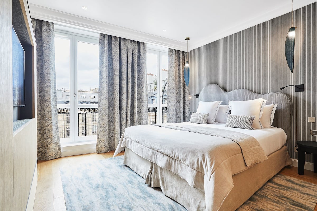 Quarto com cama grande, vista da cidade e design moderno.