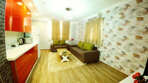 Um espaço compacto com cozinha compacta, sofá e parede estampada.