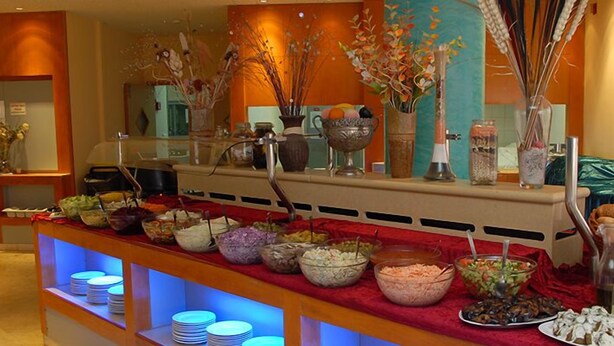 Buffet com diversos alimentos e uma seleção de bebidas.