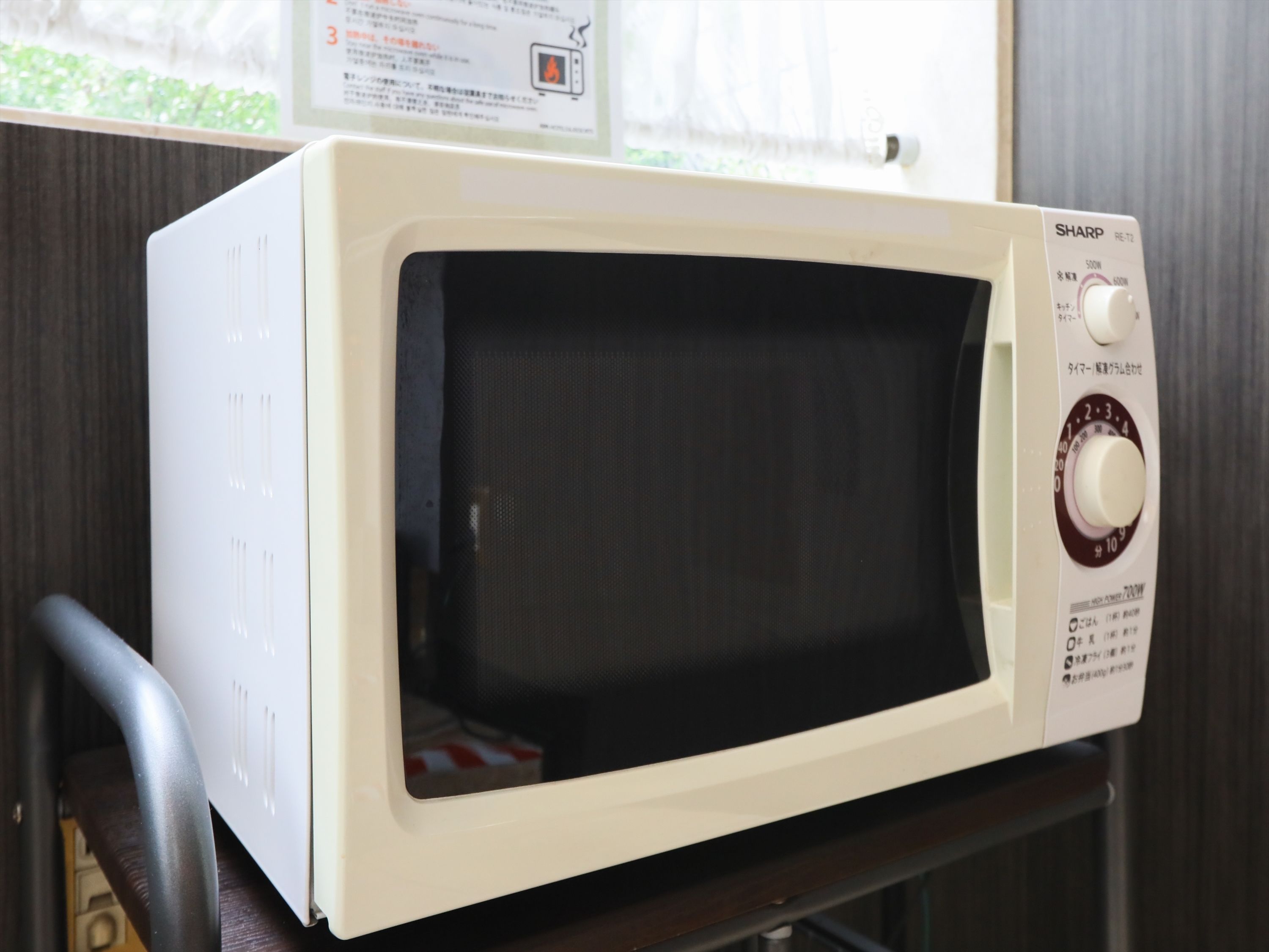 Um micro-ondas Sharp branco com painel de controle no lado direito.