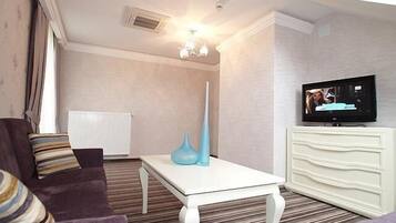 Uma sala de estar moderna com um sofá, uma mesa de centro, uma televisão e um radiador.