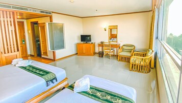 Quarto de hotel com duas camas, televisão, secretária com cadeira, janela e varanda.