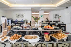 Disposição de buffet com diversos alimentos e bebidas.