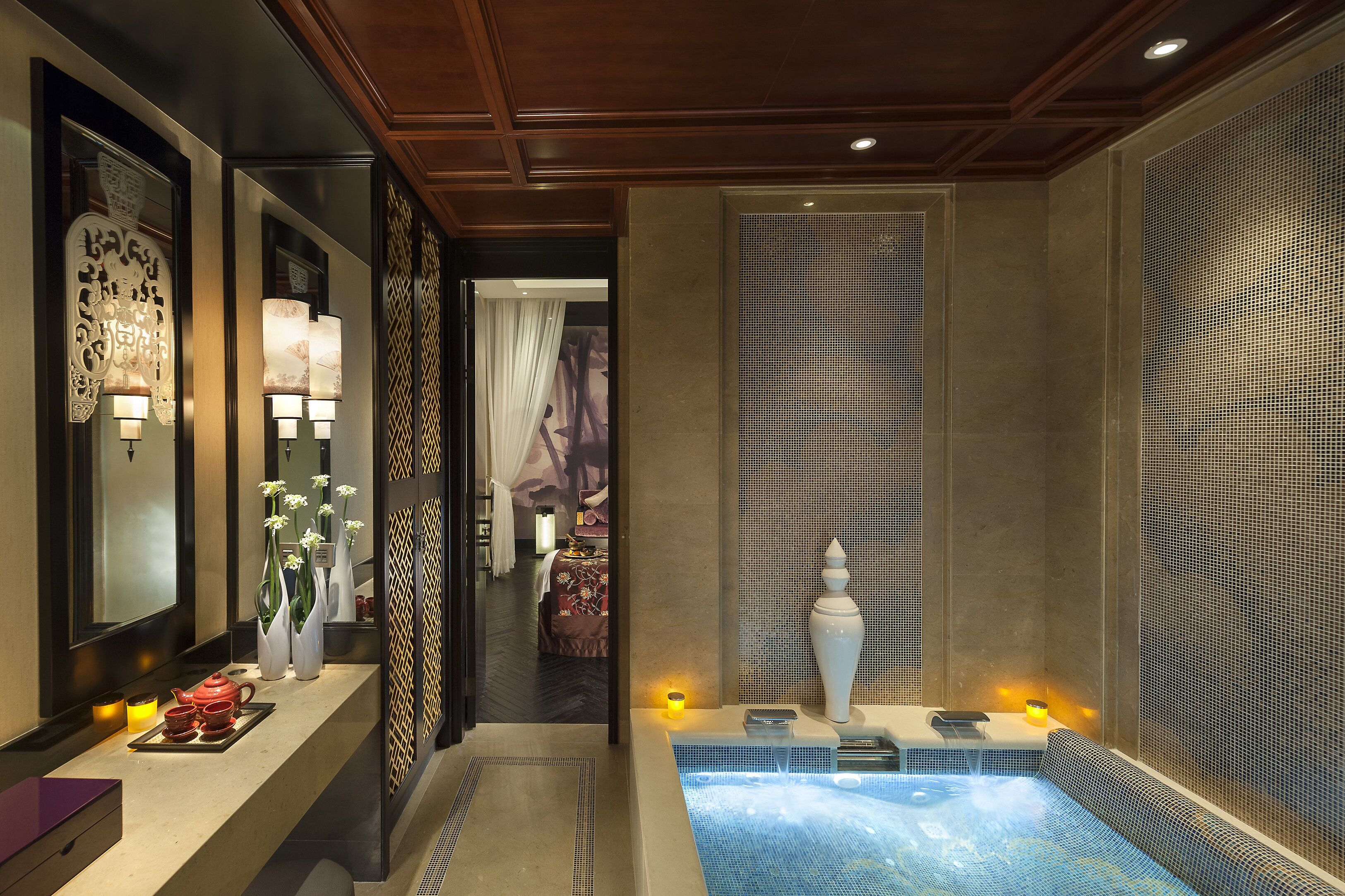 Um spa moderno com hidromassagem, painéis decorativos e uma área de recepção com jogos de chá.