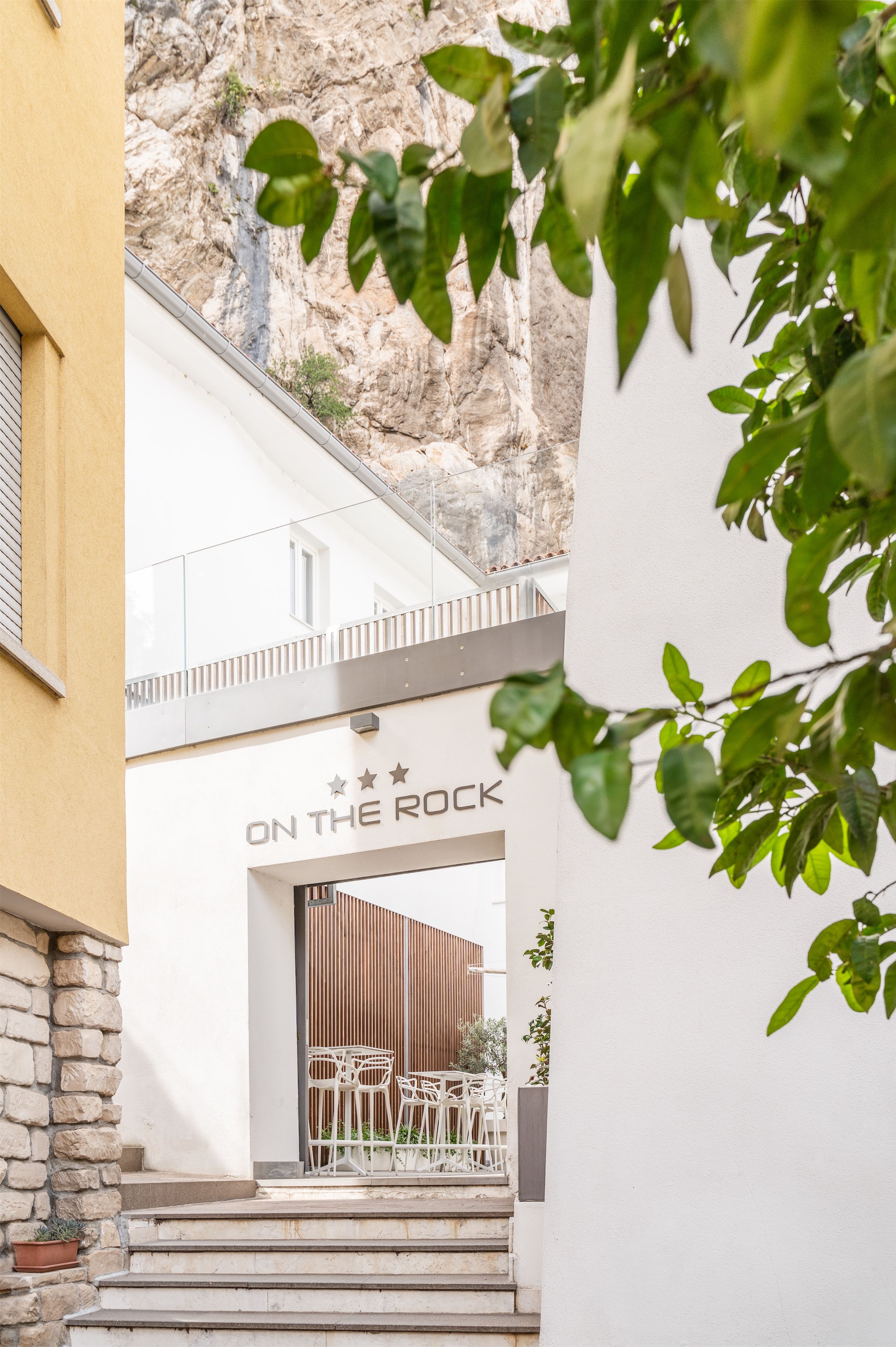 Entrada de hotel com uma placa que diz 'ON THE ROCK'.
