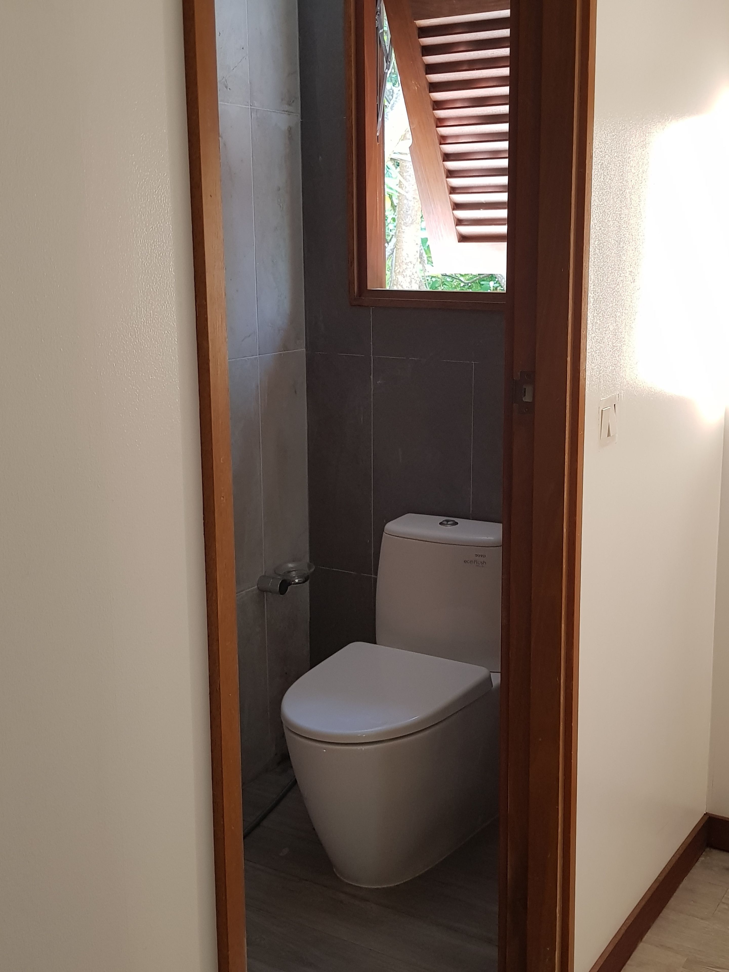 Casa de banho pequena e fechada, com sanita e cabine de duche.