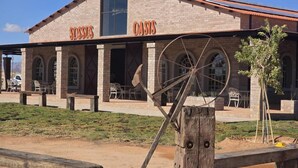 Um edifício com o nome 'OASIS' na fachada, com janelas em arco e exterior em tijolo.