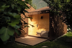 Uma cabana de madeira com varanda, porta e janela.