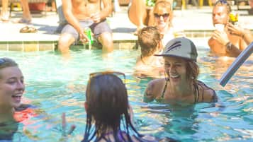 Pessoas aproveitando a água em uma piscina.