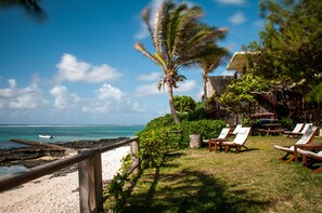 Na praia, espreguiçadeiras, toalhas de praia 