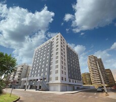 Um edifício moderno com vários andares e fachada plana.