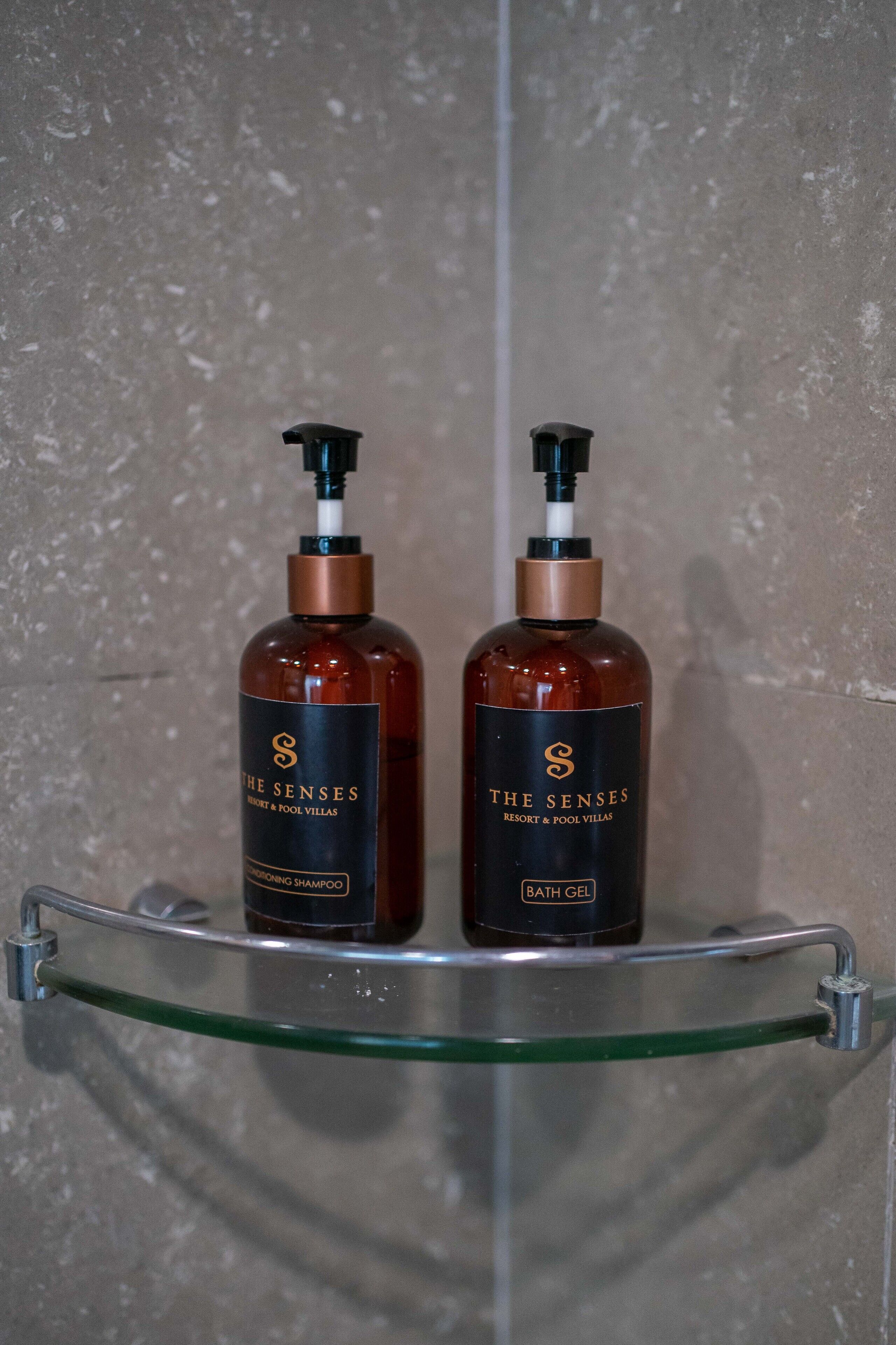Dois produtos do The Senses Resort & Pool Villas sobre uma prateleira de vidro.