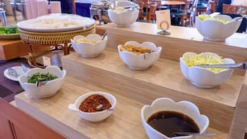 Uma mesa de buffet com diversos alimentos e acompanhamentos.