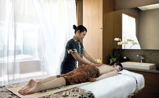 Sessão de massagem em sala de spa moderna, com um espelho grande, pia e janela com cortinas leves.