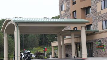 Um edifício com entrada coberta, uma placa com 'The Bistro' e motocicletas estacionadas.