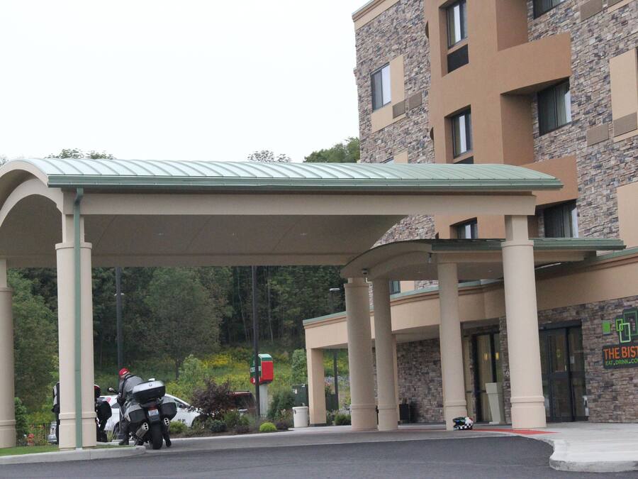 Um edifício com entrada coberta, uma placa com 'The Bistro' e motocicletas estacionadas.