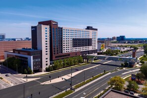 Um hotel moderno com um grande letreiro Radisson, vários andares e área de estacionamento.