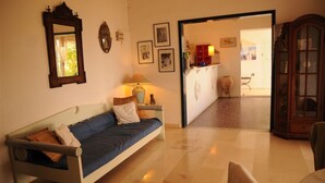 Um quarto com sofá, luminária, espelho e armário.