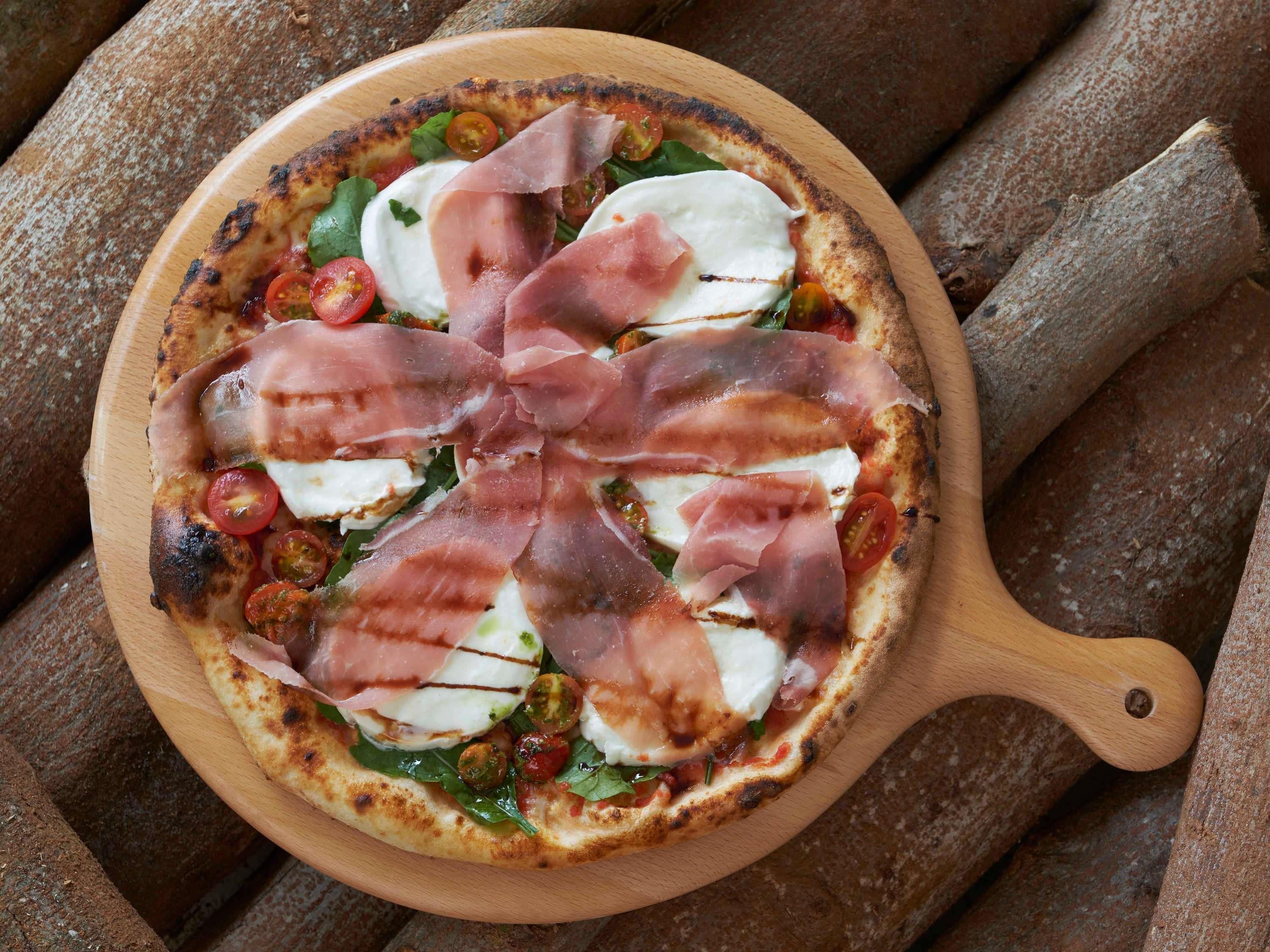 Pizza sobre uma tábua de madeira com fundo rústico.