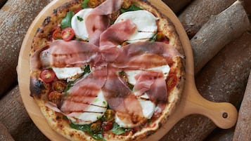 Pizza sobre uma tábua de madeira com fundo rústico.