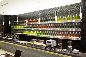 Disposição de buffet com vários dispensadores de bebidas e estações de comida.