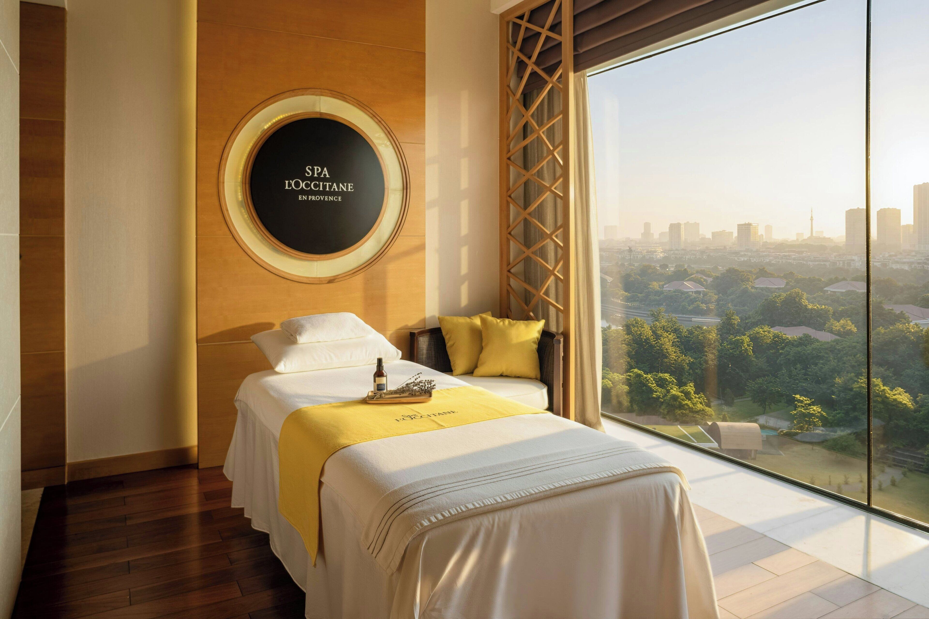 Quarto de hotel com cama, vista da cidade e um sinal circular na parede.