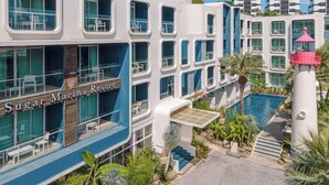 Um edifício de resort com várias varandas e área de piscina.