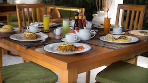 Uma mesa de jantar posta com pratos de comida, chávenas e um bule.
