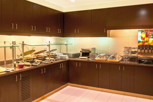 Uma cozinha moderna com armários de madeira escura, uma vitrine de vidro e uma máquina de café.