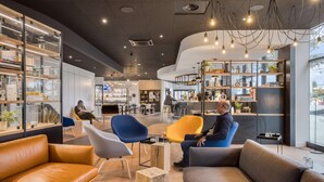 Um interior moderno com sofás de couro, uma mesa de centro e uma estante de livros.