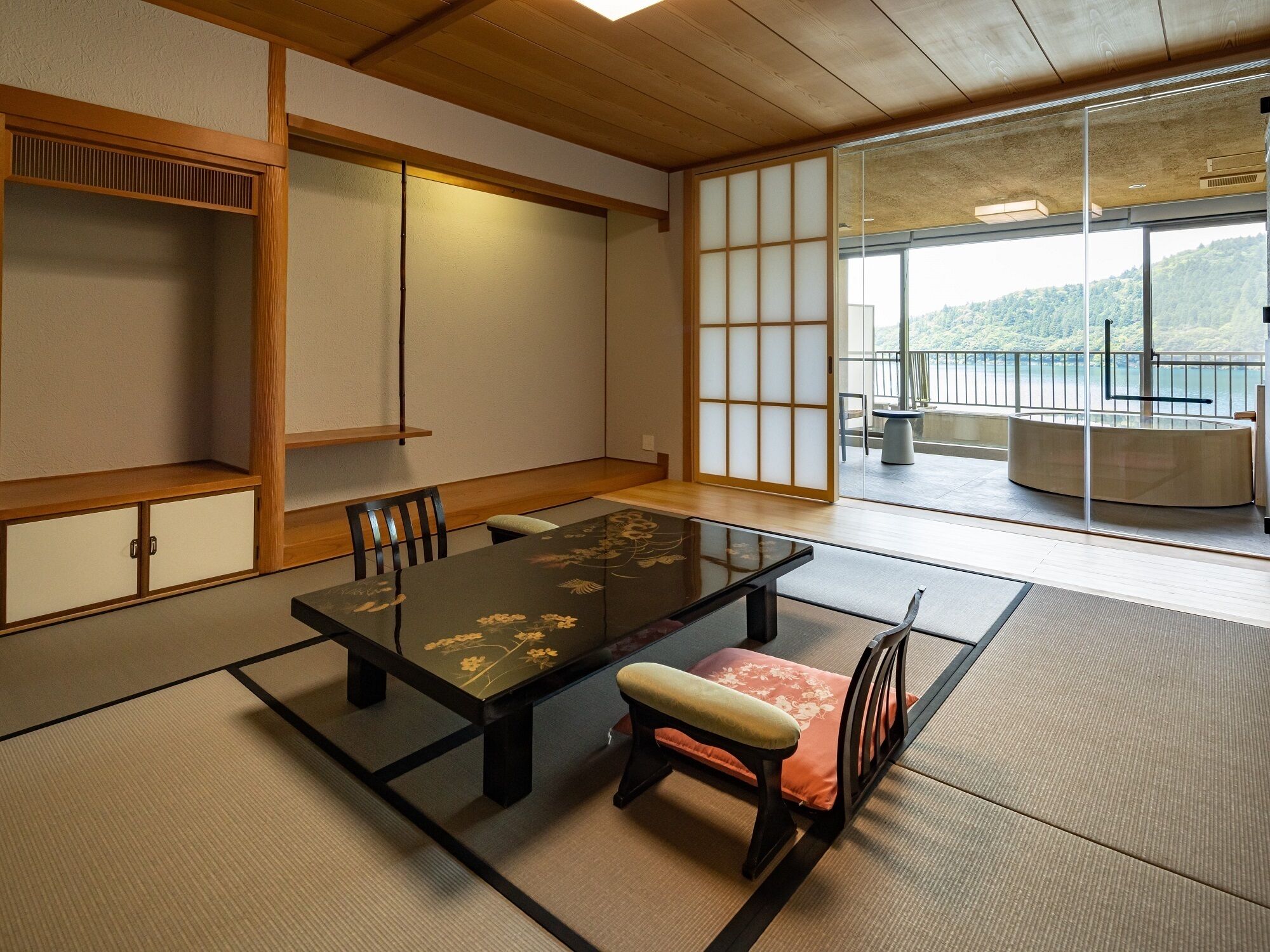 Um quarto japonês tradicional com piso de tatame, uma mesa baixa e portas deslizantes.