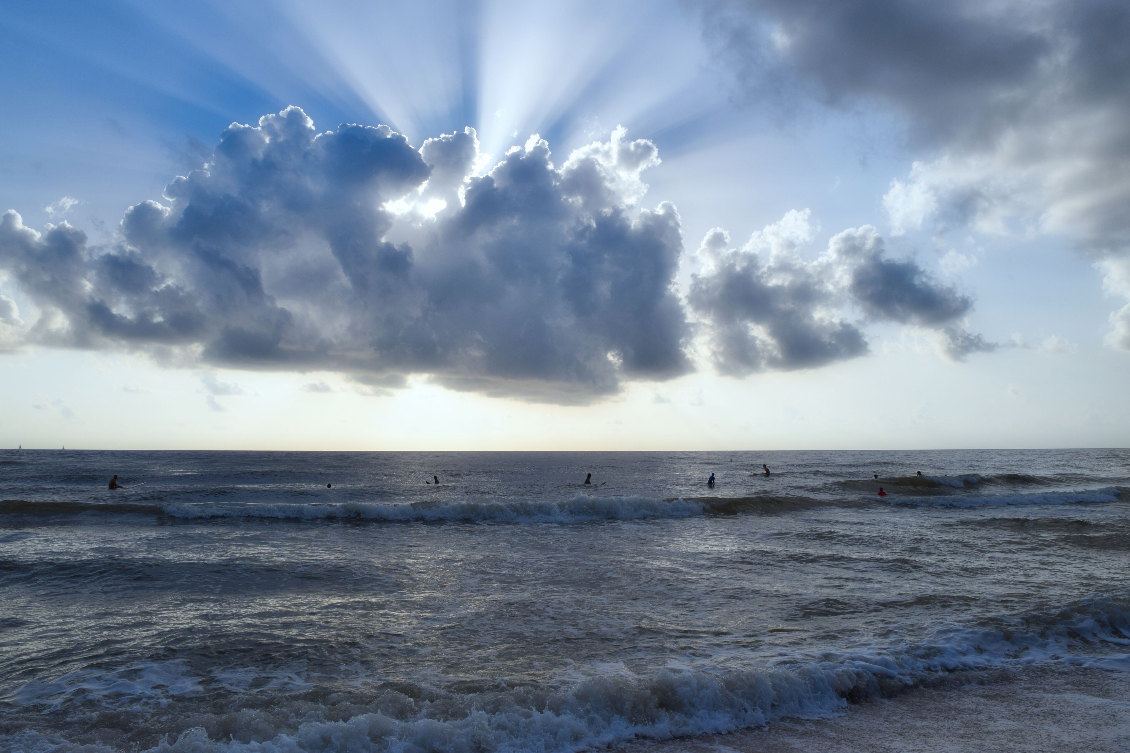 Uma praia com ondas e um céu nublado.