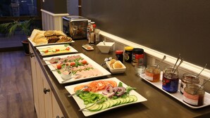 Disposição de buffet com diversos alimentos e acompanhamentos.