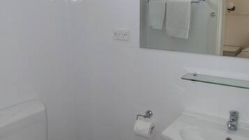 Um banheiro pequeno com vaso sanitário, pia e espelho.