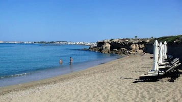 Na praia, espreguiçadeiras, guarda-sóis de praia, toalhas de praia