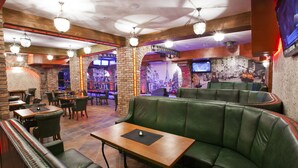 Um restaurante com cabines, mesas e um bar.