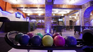 Uma pista de boliche com várias pistas, área de bar e assentos.