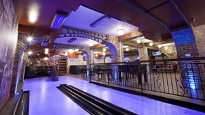 Uma pista de boliche com design moderno, incluindo um bar e área de estar.