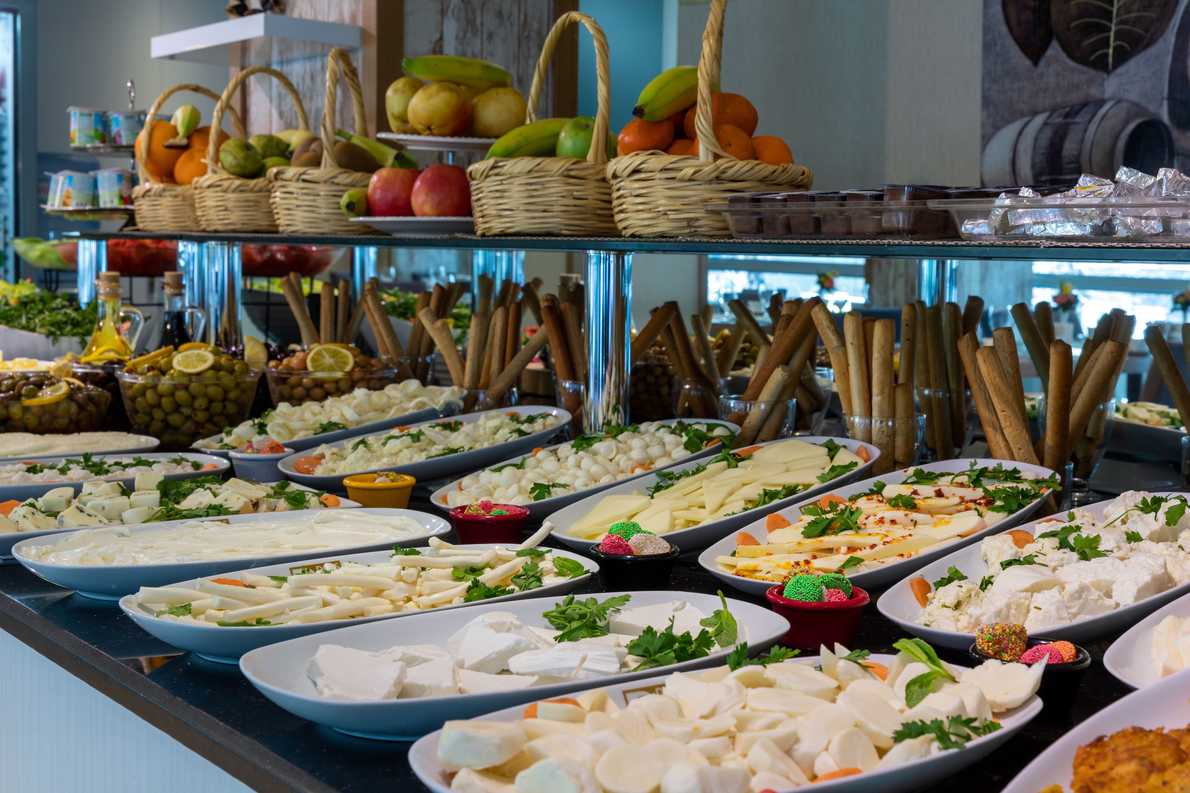 Buffet com diversos alimentos e frutas.