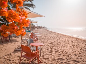 Uma praia privada, espreguiçadeiras, guarda-sóis de praia 