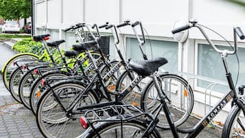Várias bicicletas estacionadas em frente a um edifício.