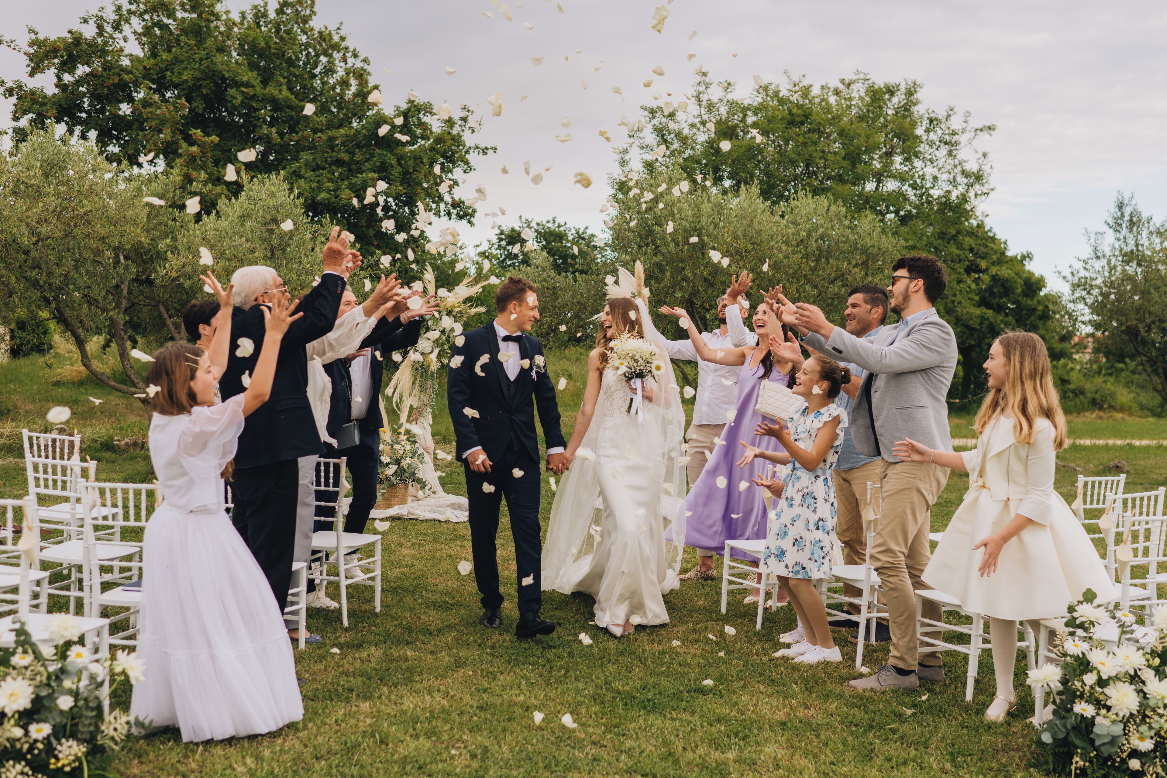 Cerimônia de casamento com convidados atirando pétalas de flores.