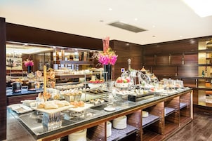 Disposição de buffet com diversos alimentos e um arranjo decorativo.