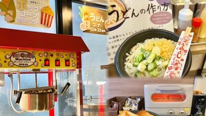 Máquina de pipocas, uma tigela de ramen e pão tostado.
