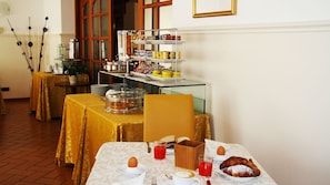 Um buffet de café da manhã com diversos alimentos e uma estação de café.